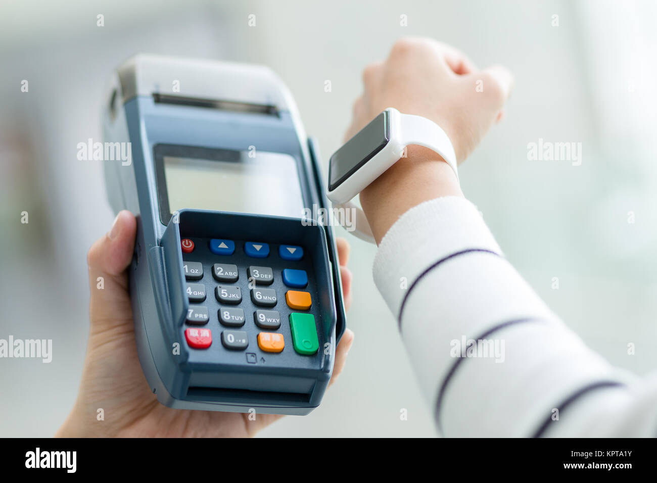 Woman using smartwatch to pay the bill Stock Photo - Alamy