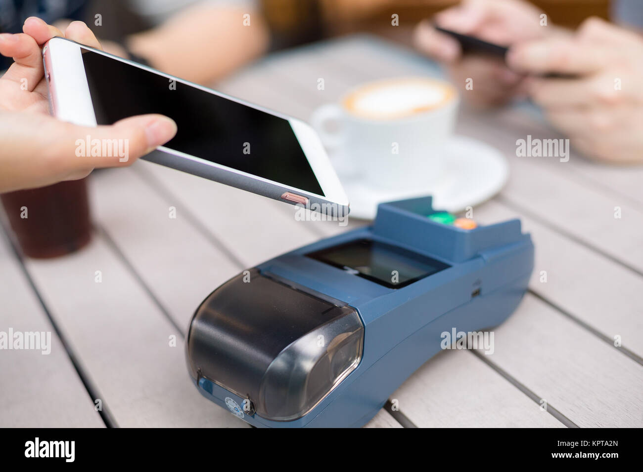 Customer pay on pos machine with mobile phone Stock Photo - Alamy