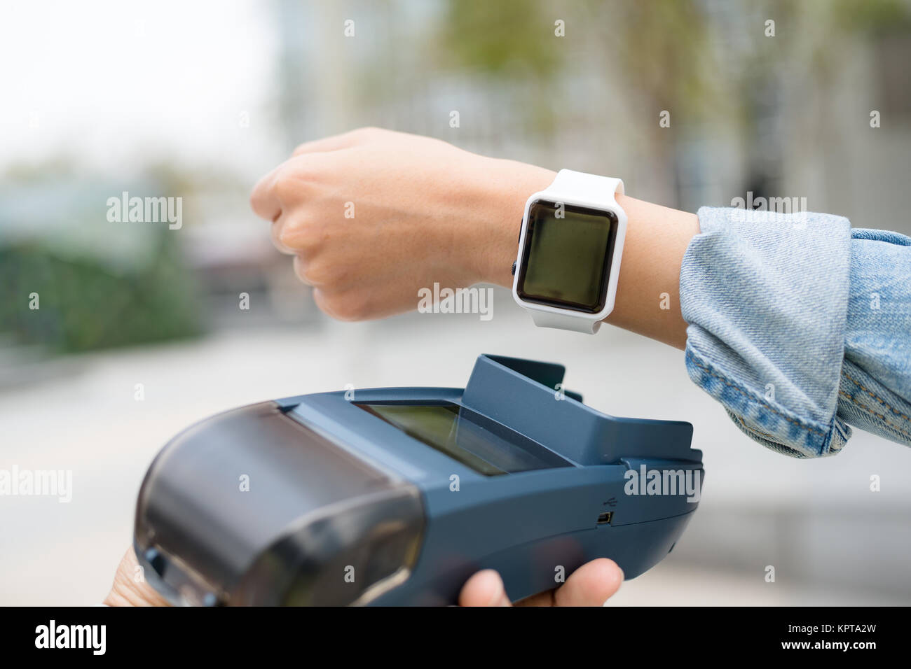 Customer using wearable watch to checkout Stock Photo - Alamy