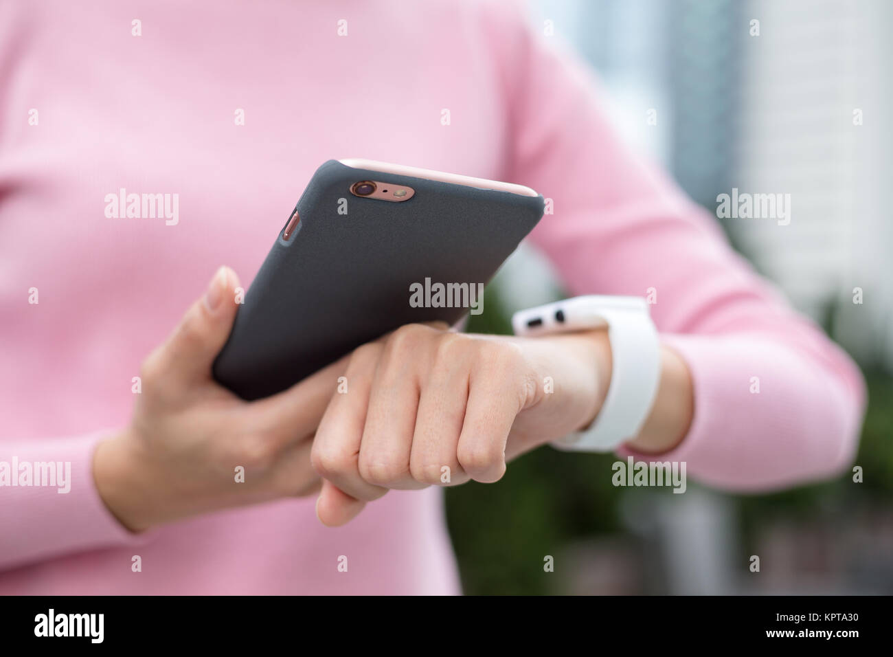 Woman using smart watch and connecting with cellphone Stock Photo - Alamy