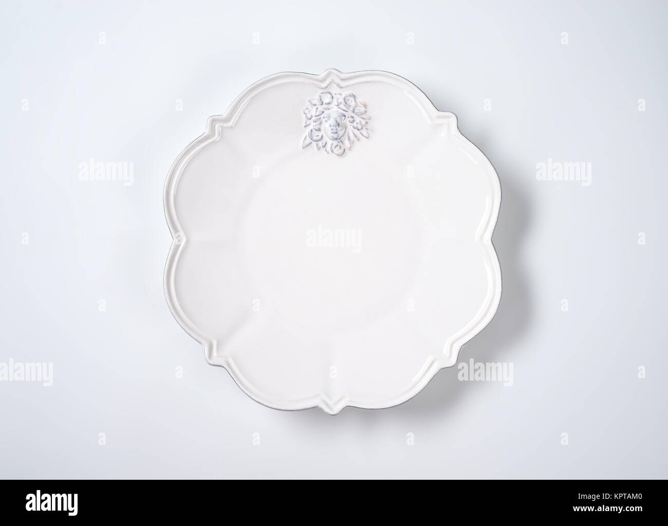 white embossed ceramic plate with decorative edge Stock Photo - Alamy