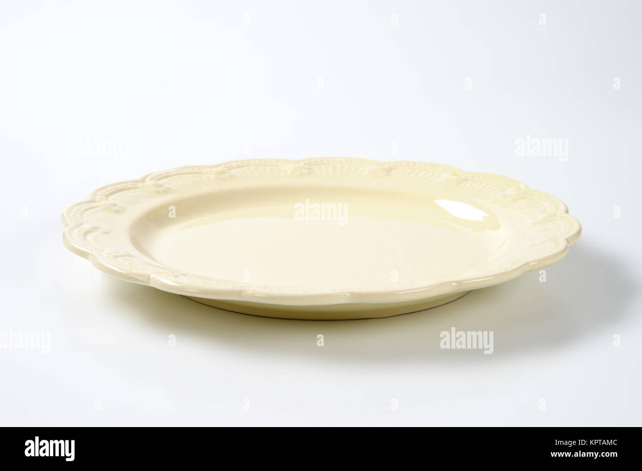 beige plate with embossed rim Stock Photo - Alamy