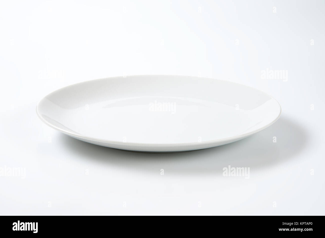 empty rimless white plate on off-white background Stock Photo - Alamy