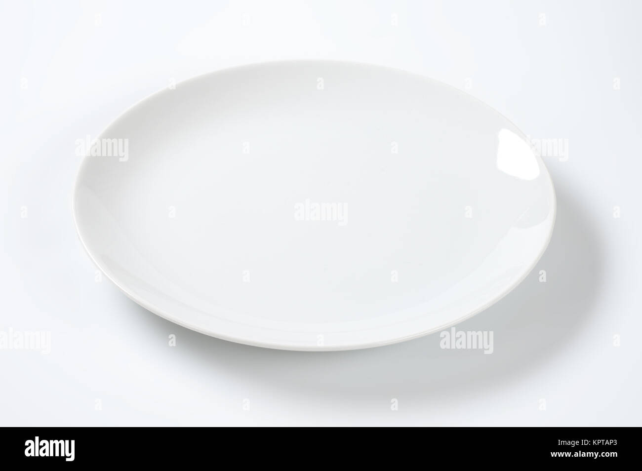 empty rimless white plate on off-white background Stock Photo - Alamy