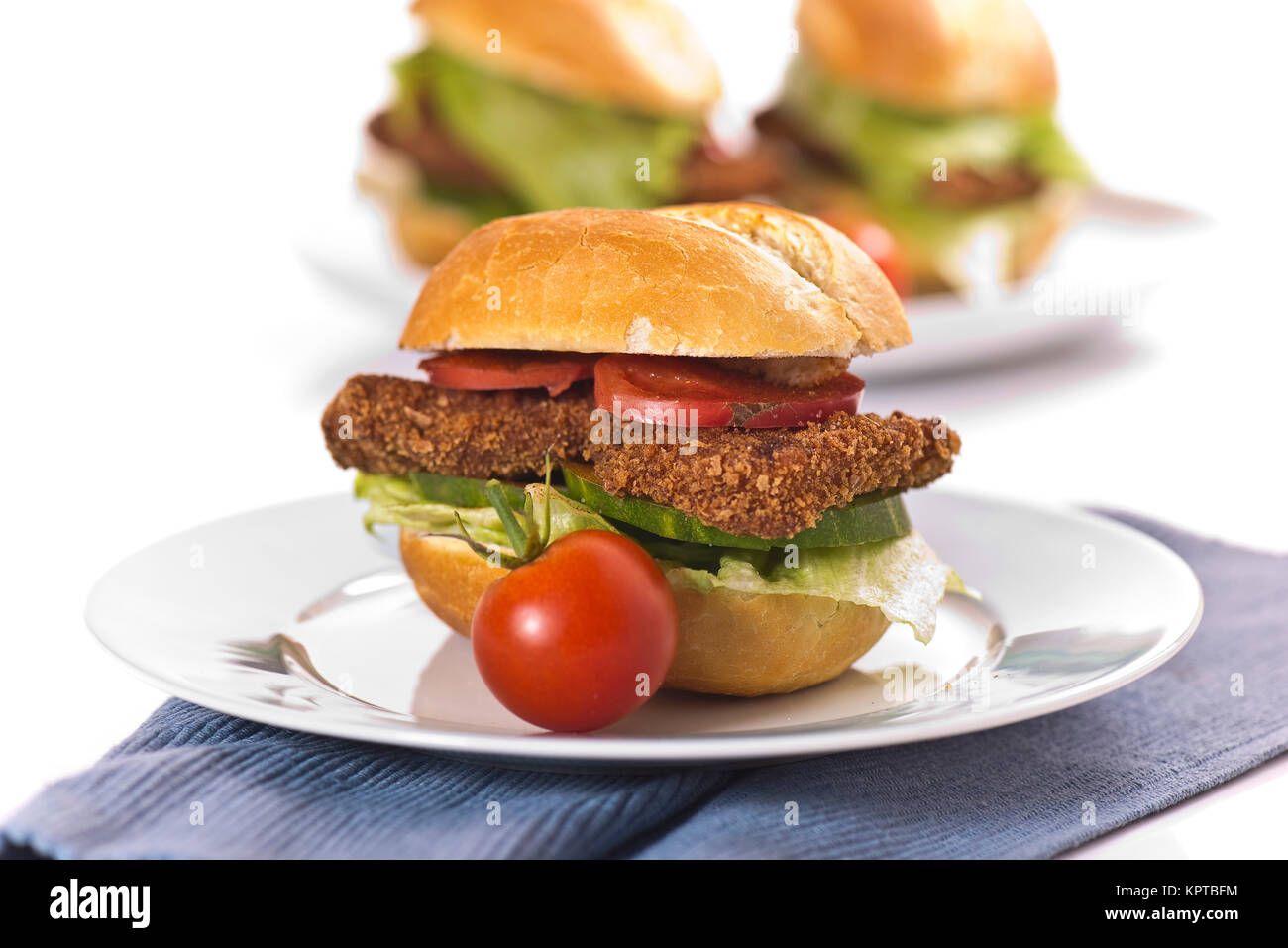 Schnitzelbrötchen auf weißem Hintergrund mit frischer Tomate, Salat und ...