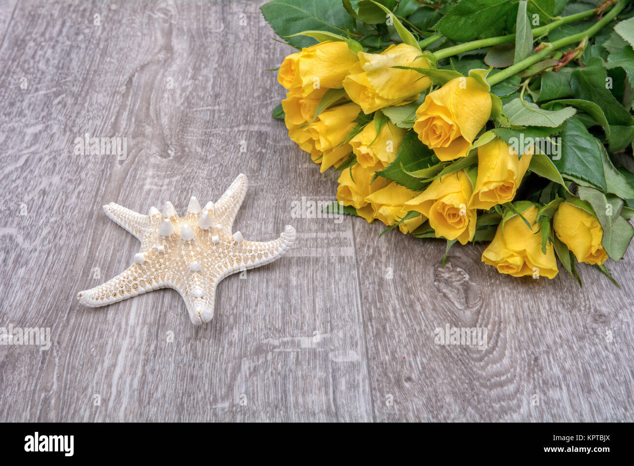 White starfish and yellow roses on a wooden background Stock Photo - Alamy