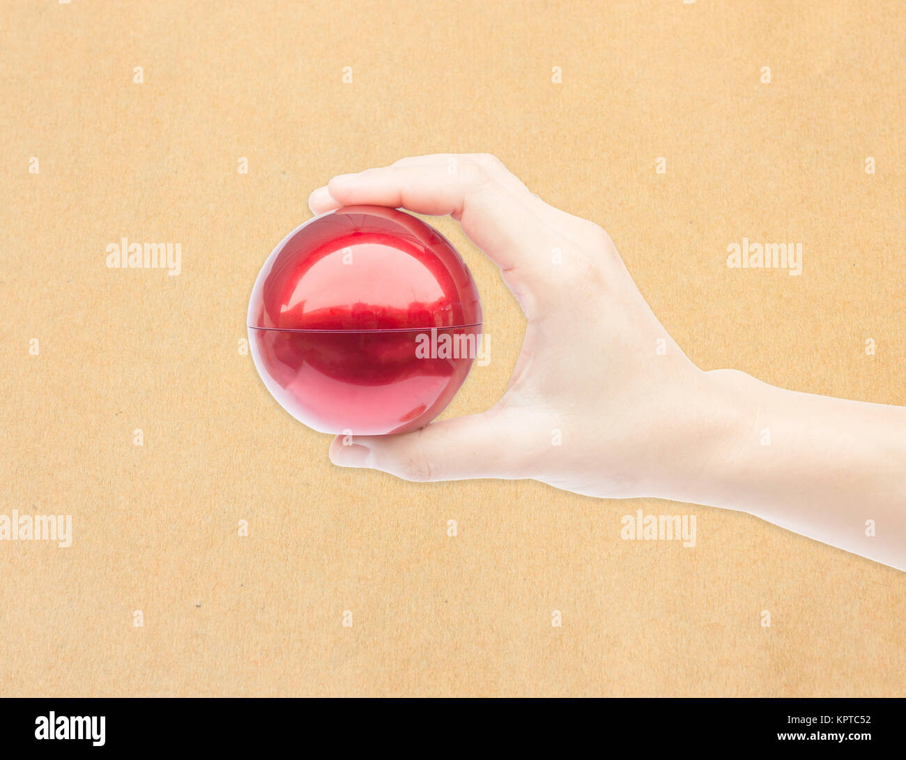 Hand on shiny red ball on brown background, stock photo Stock Photo - Alamy