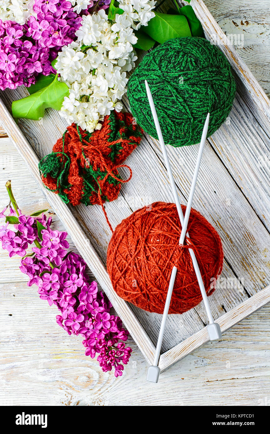 Balls of wool yarn for knitting and branches of lilac blossoms Stock ...