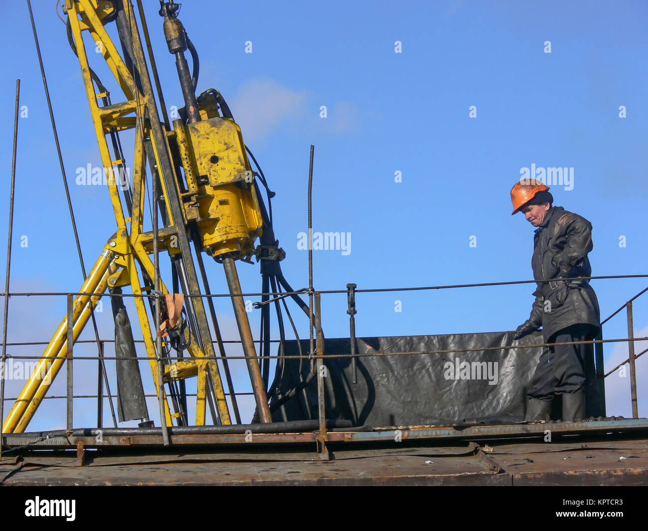 worker checks the equipment on the rig for coring. The trailer with the ...
