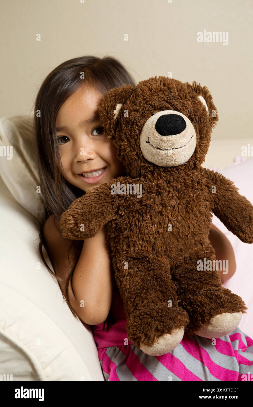 Cute little girl hugging her bear Stock Photo - Alamy