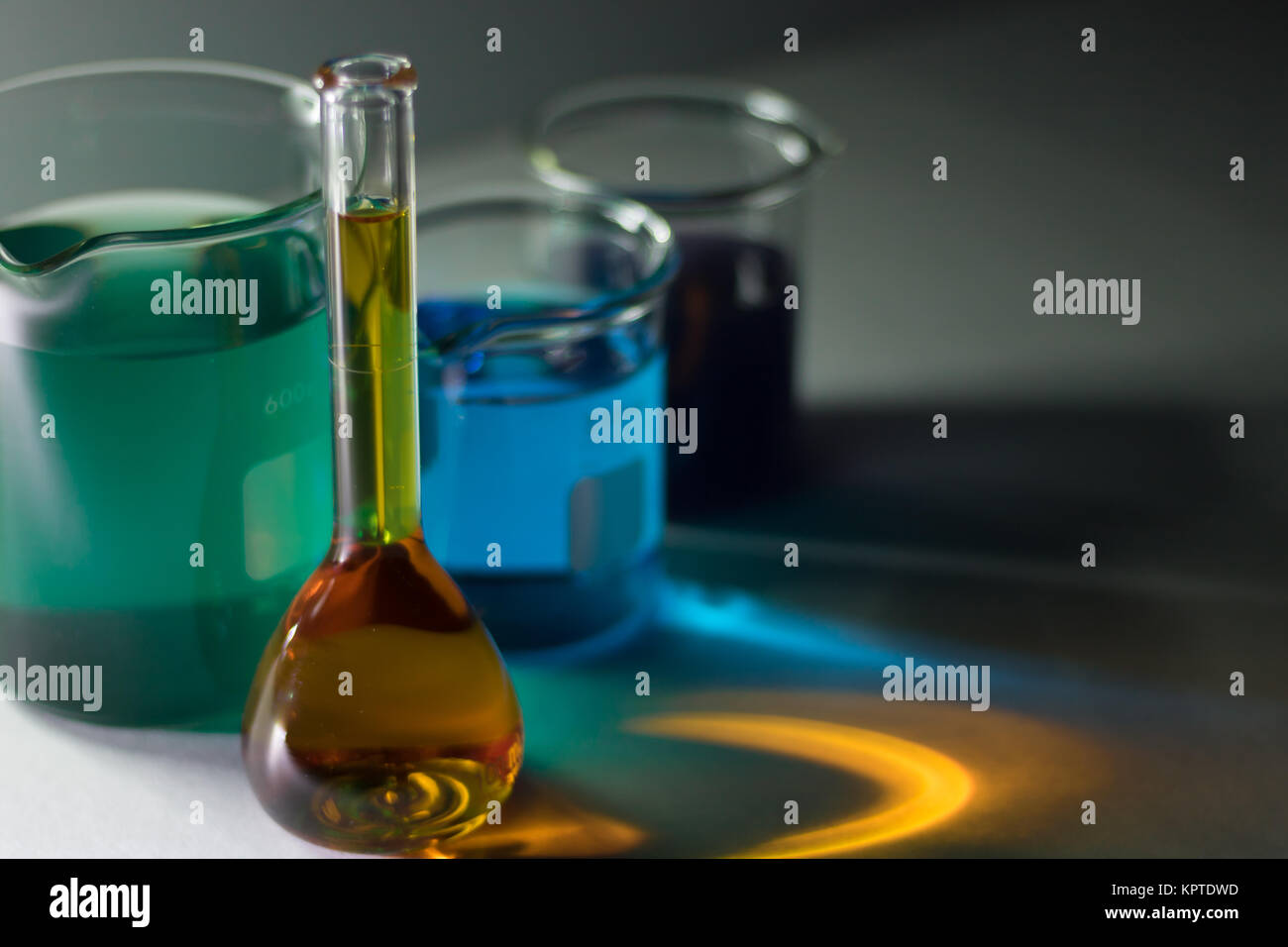 Laboratory glassware with liquid chemicals isolated over gray ...
