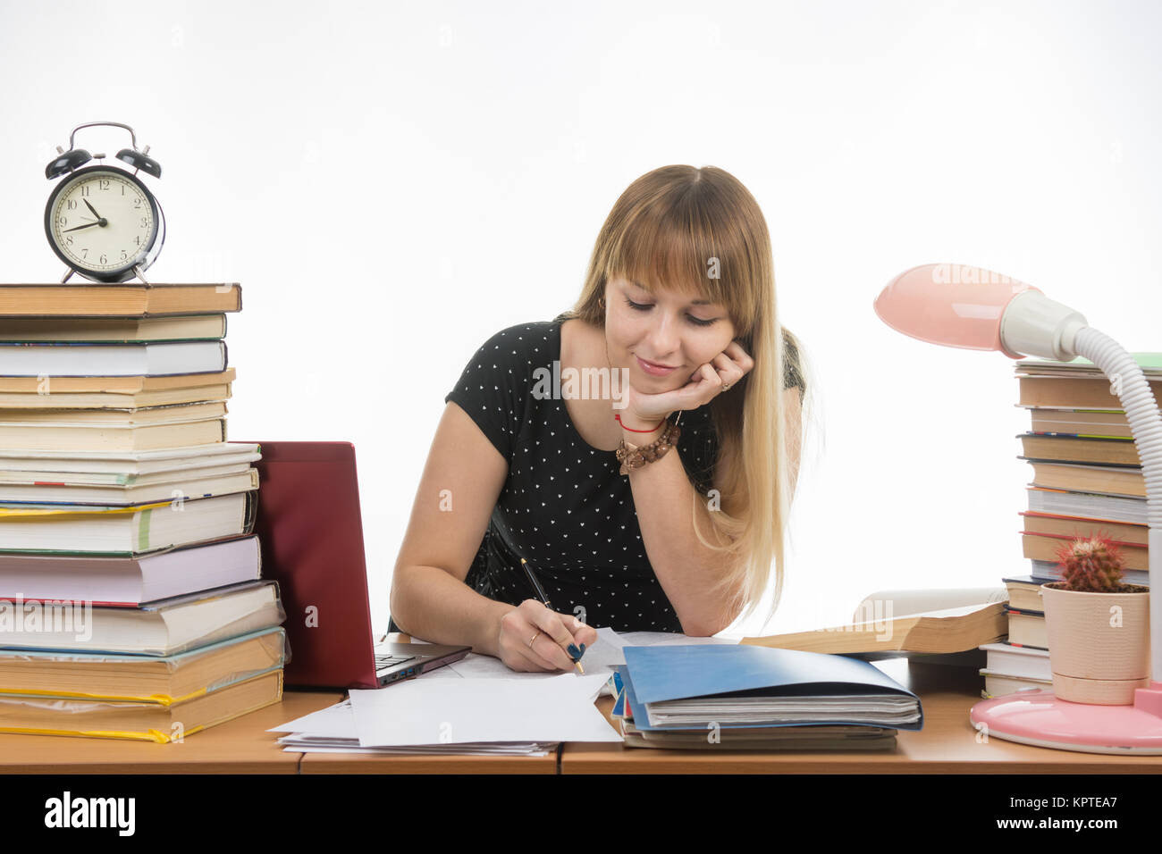 college student smiling engaged at the table cluttered with books in ...