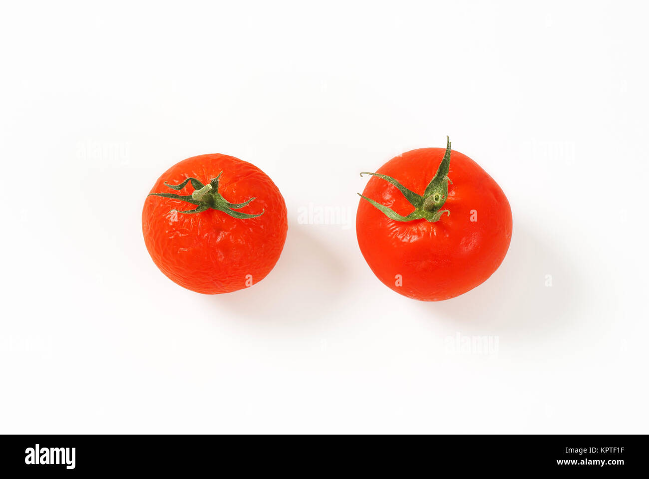 two tomatoes going bad, on white background Stock Photo - Alamy