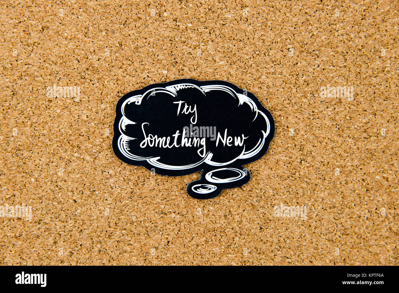 Try Something New written on black thinking bubble over cork board ...