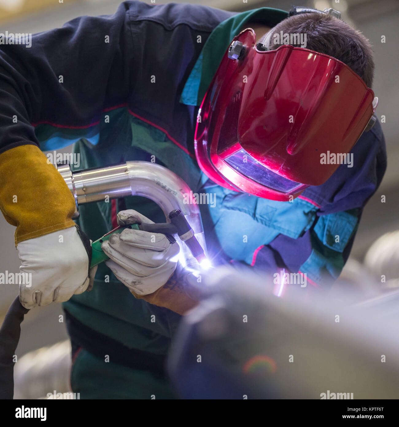 Industrial worker with protective mask welding inox elements in steel ...