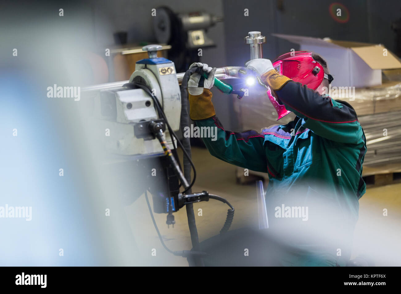 Industrial worker with protective mask welding inox elements in steel ...