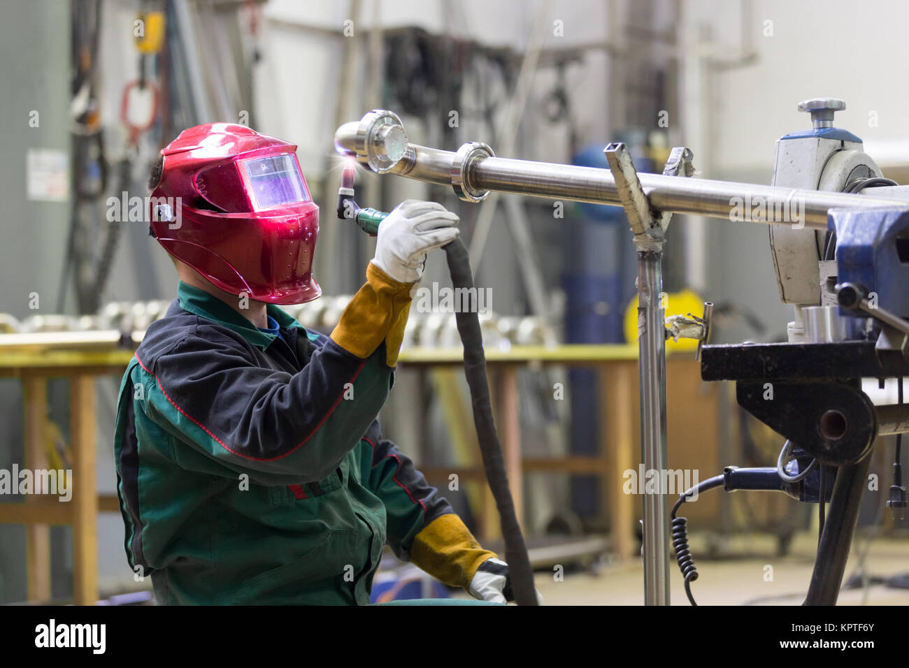 Industrial worker with protective mask welding inox elements in steel ...