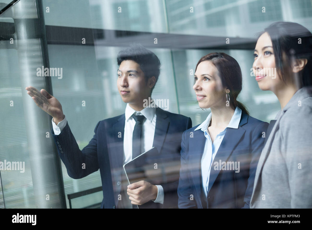 Group of business people looking though window Stock Photo - Alamy