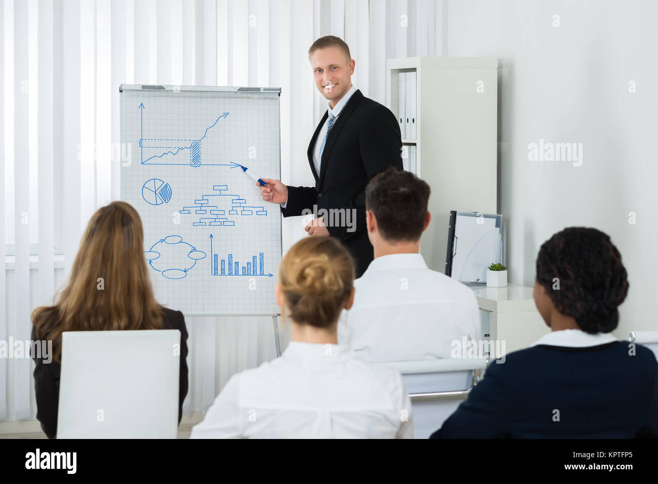 Businessman Explaining Business Chart To His Colleagues Stock Photo - Alamy