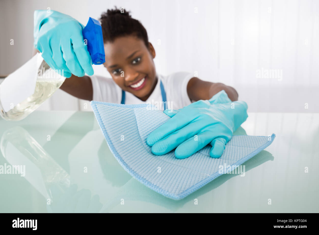 Happy Female Janitor Cleaning Desk With Rag Stock Photo - Alamy