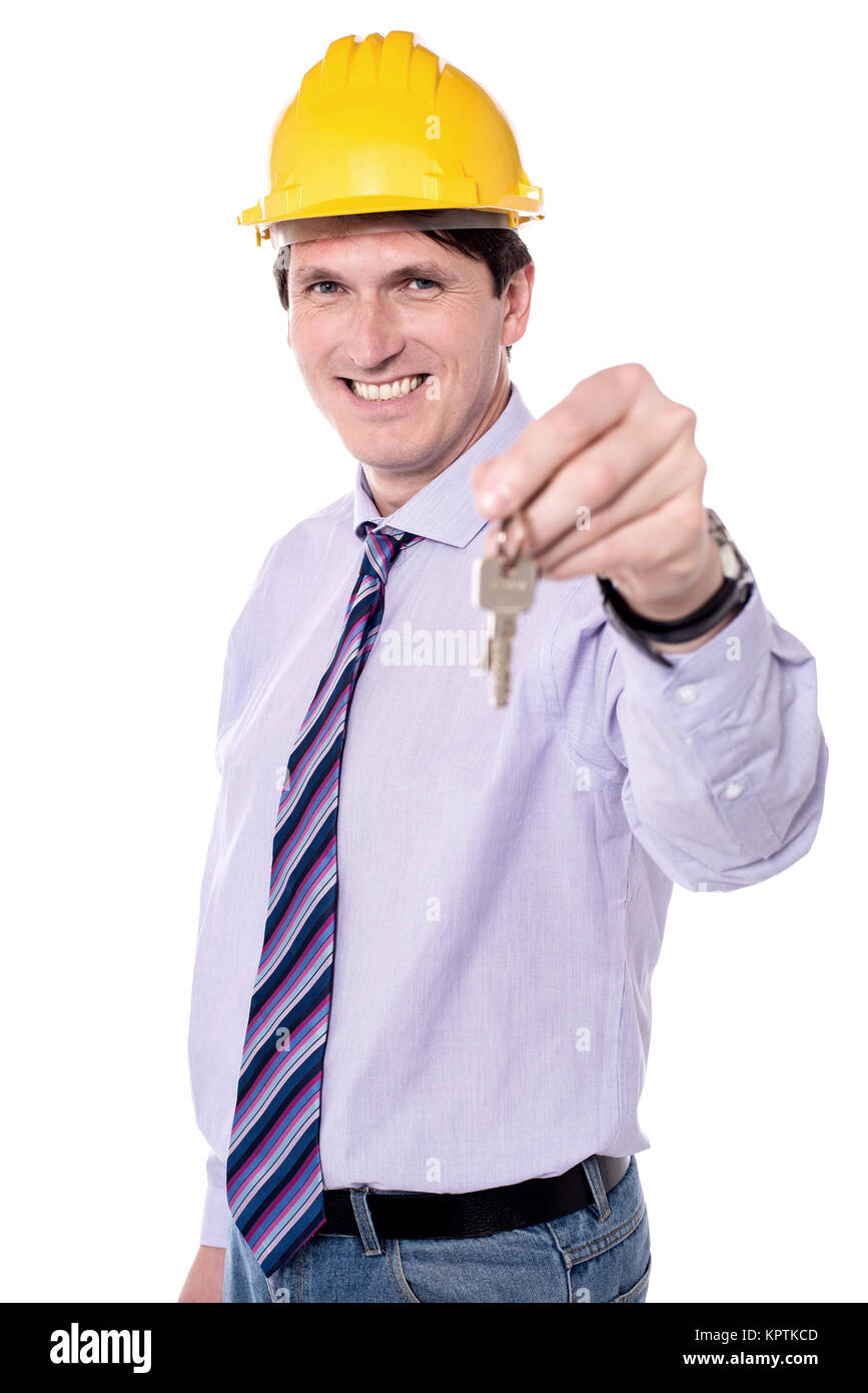 Happy male builder offering new house keys Stock Photo - Alamy