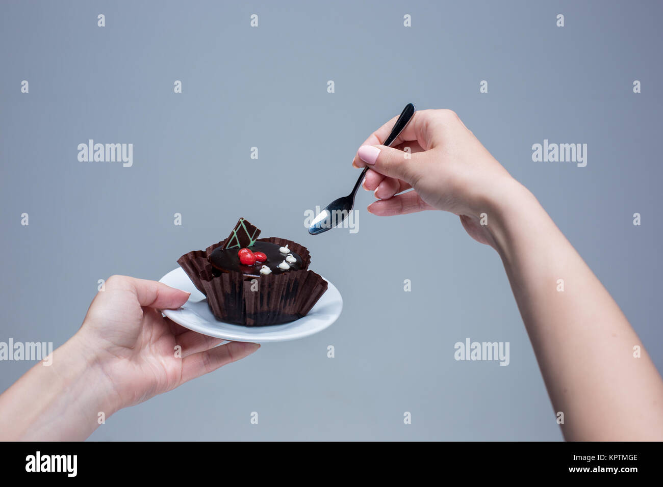 Female hands keeping cake with spoon on gray Stock Photo - Alamy