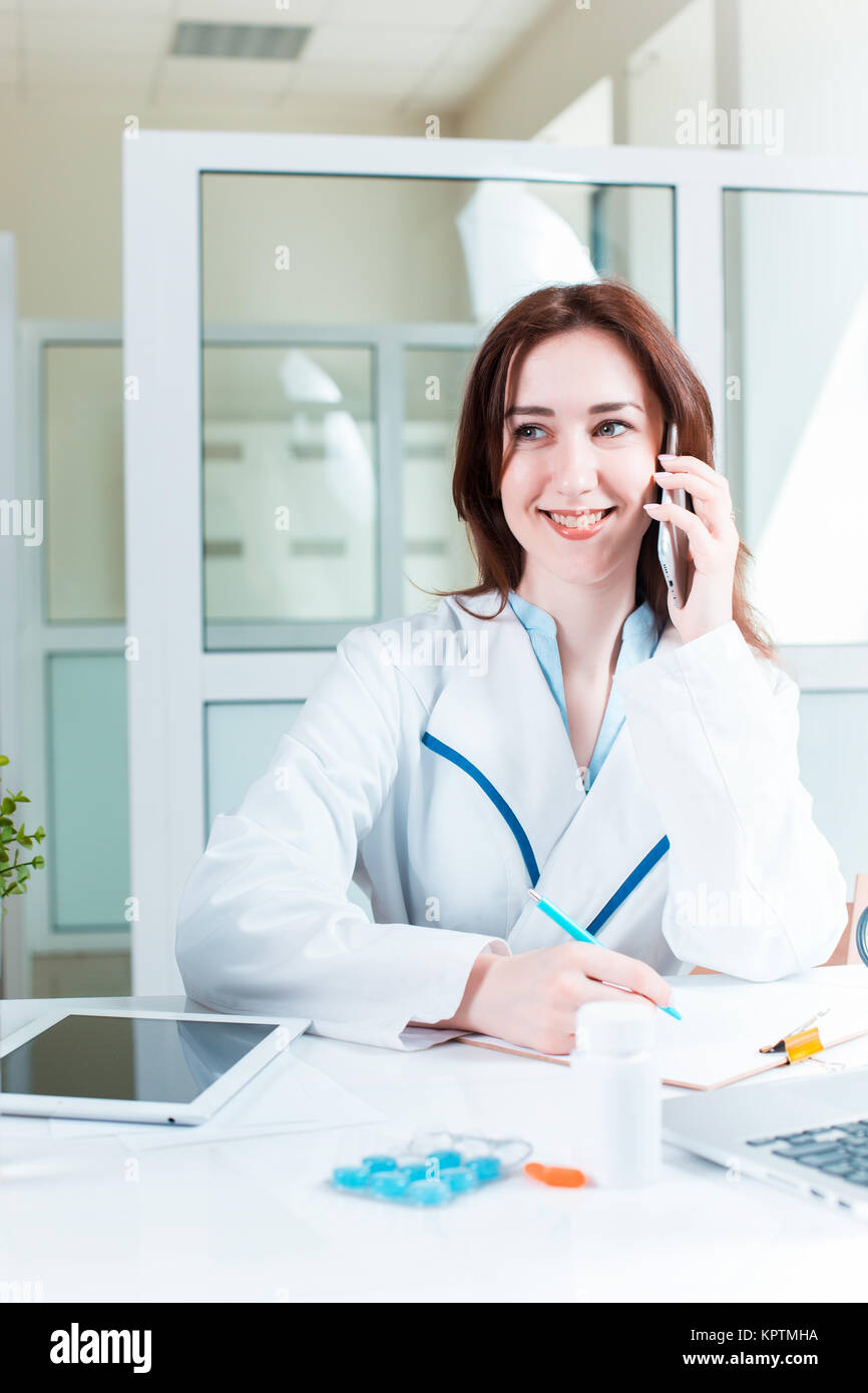 Woman doctor sitting at the table Stock Photo - Alamy