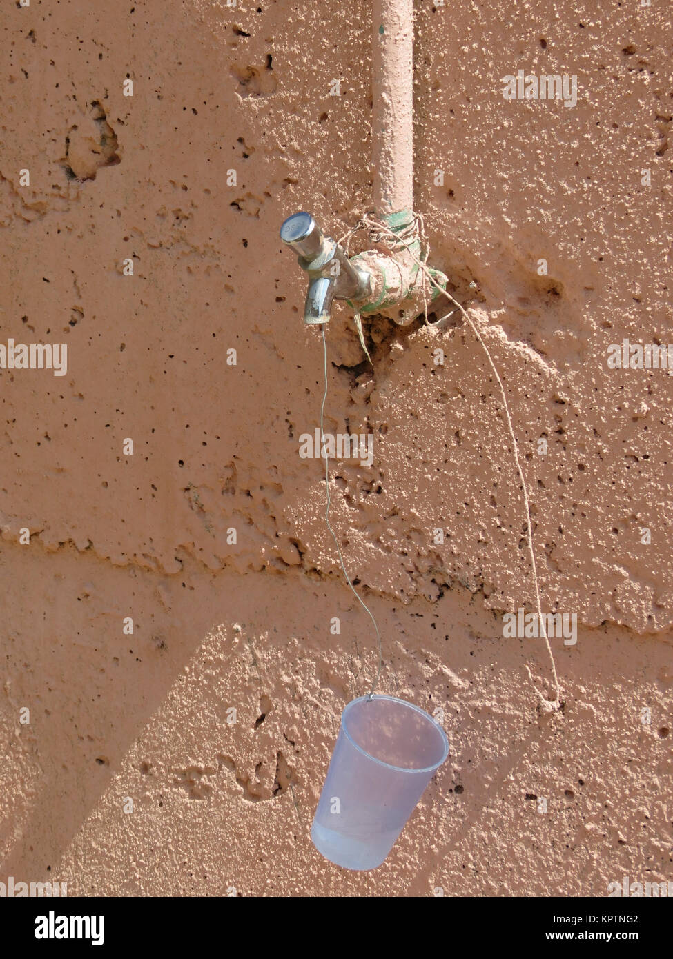 faucet with cups on a wall in oman Stock Photo - Alamy