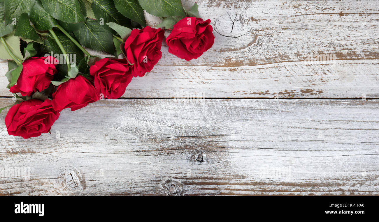 Red roses on rustic white wood in flat lay view Stock Photo - Alamy