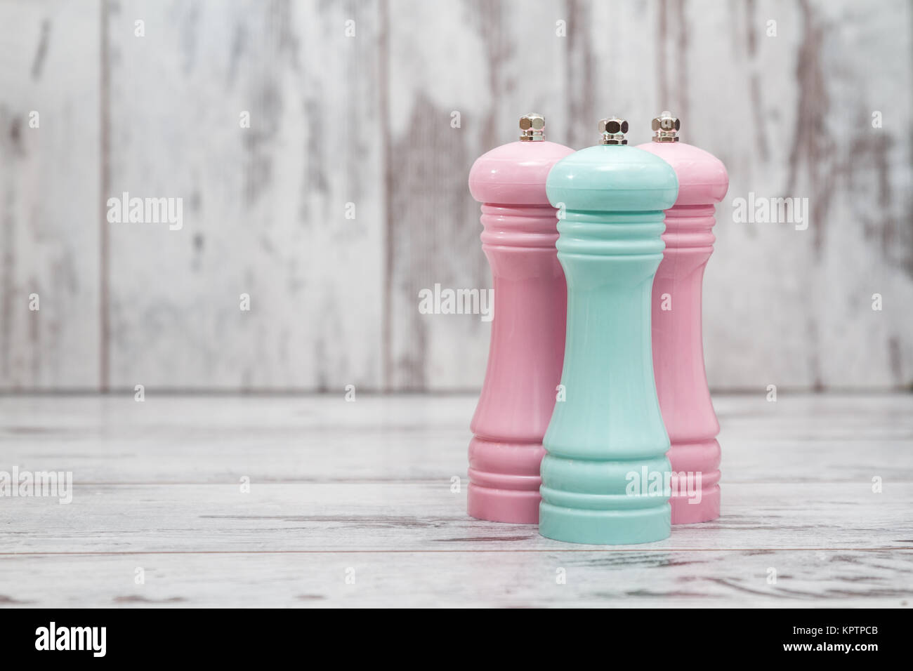 Colorful pepper mills on white wooden background Stock Photo - Alamy