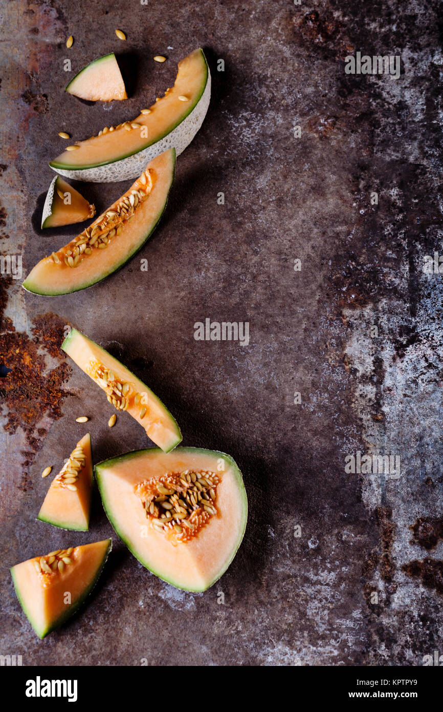 Melon slices in rusty metal background, top view Stock Photo - Alamy