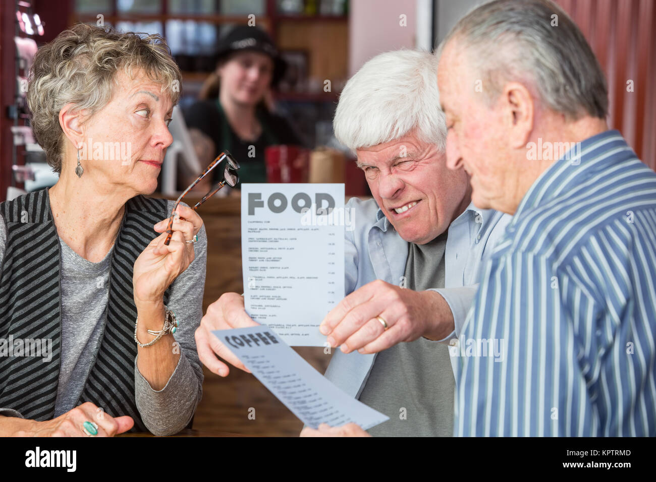 Mature man has difficulty reading menu in a cafe Stock Photo - Alamy