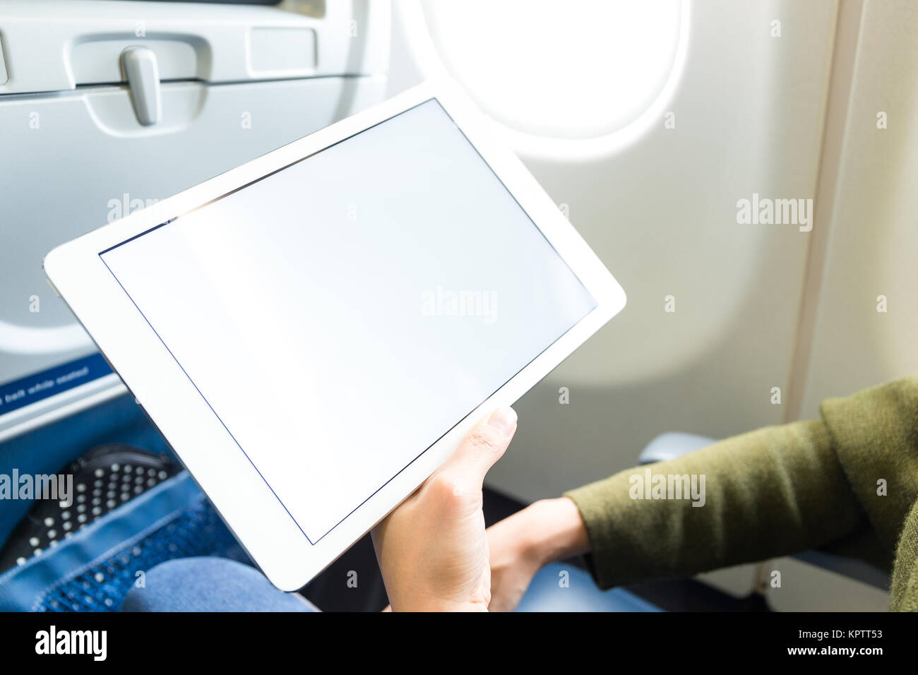 Young woman using tablet on plane Stock Photo - Alamy