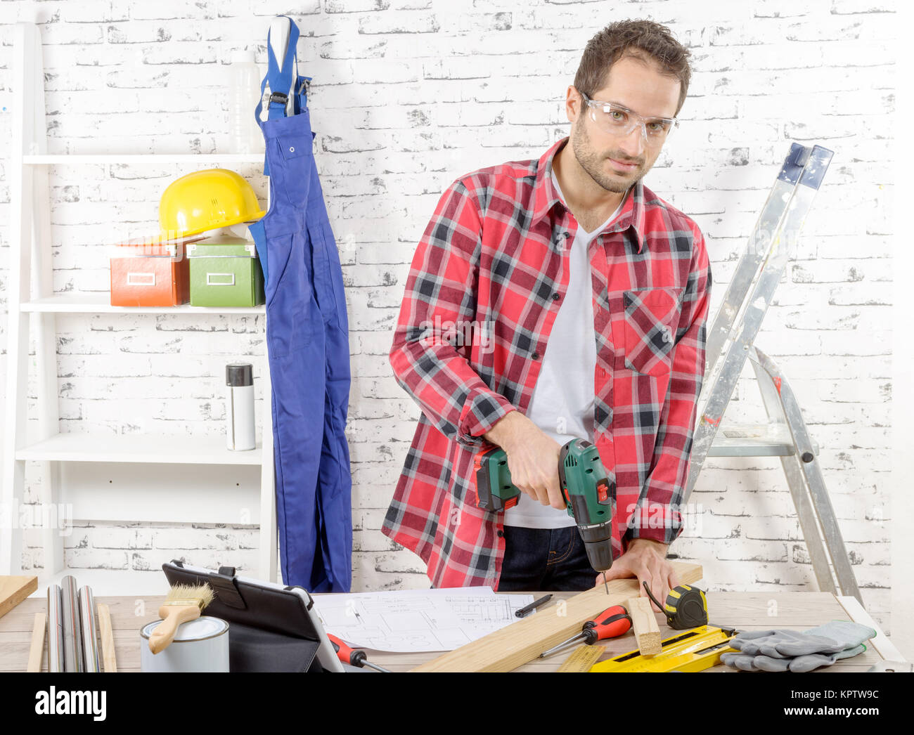 a carpenter drilling hole in plank, in his workshop Stock Photo - Alamy