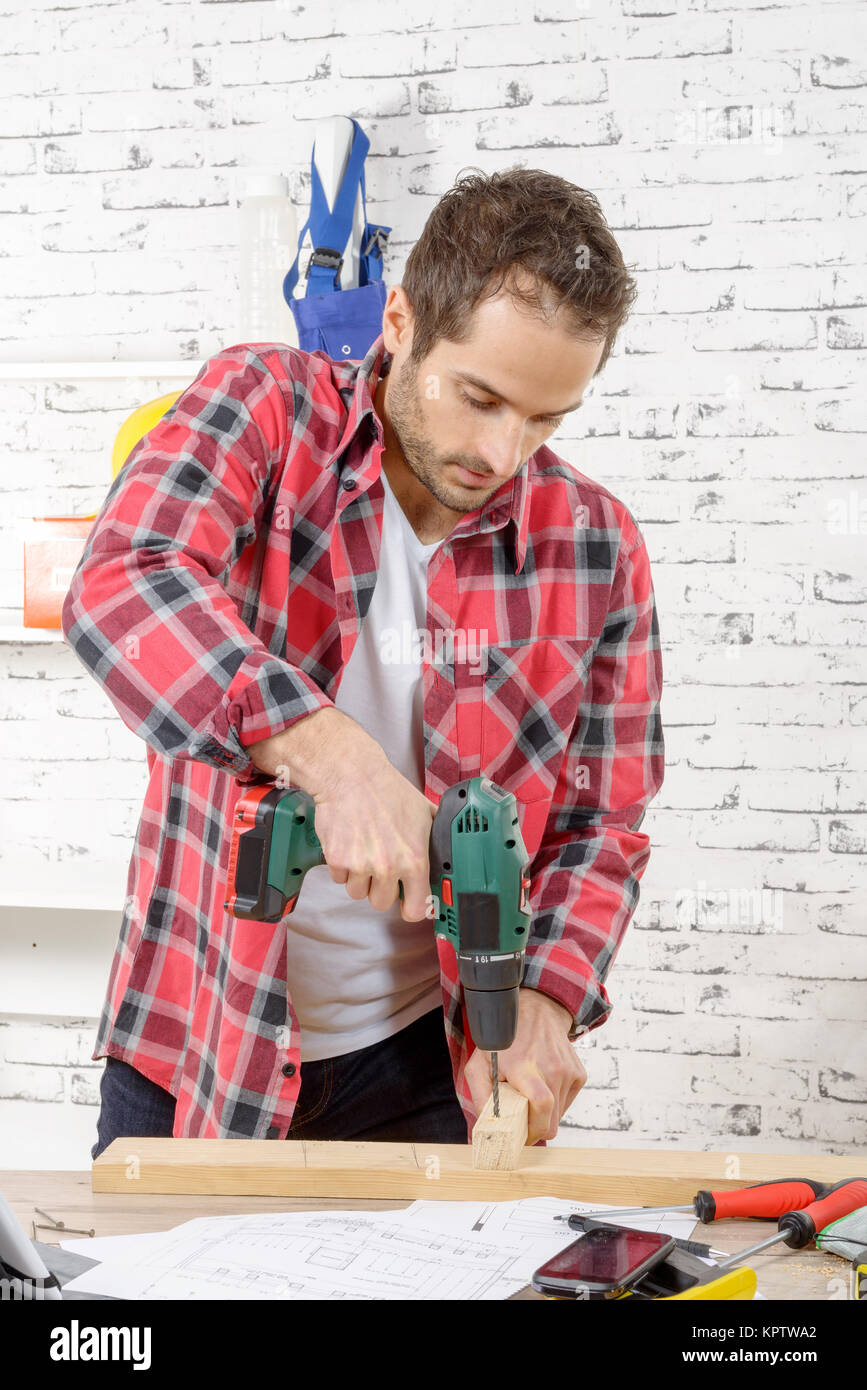 a carpenter drilling hole in plank, in his workshop Stock Photo - Alamy