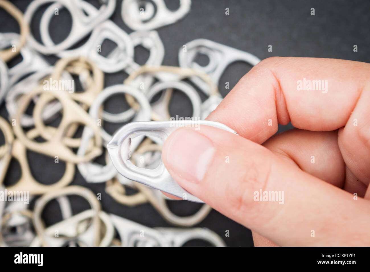 Woman hand holding ring pull cans opener background Stock Photo - Alamy