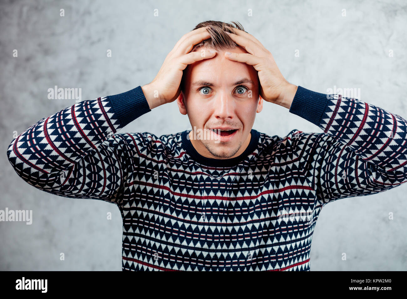 surprised man holded hands on head on concrete wall Stock Photo - Alamy