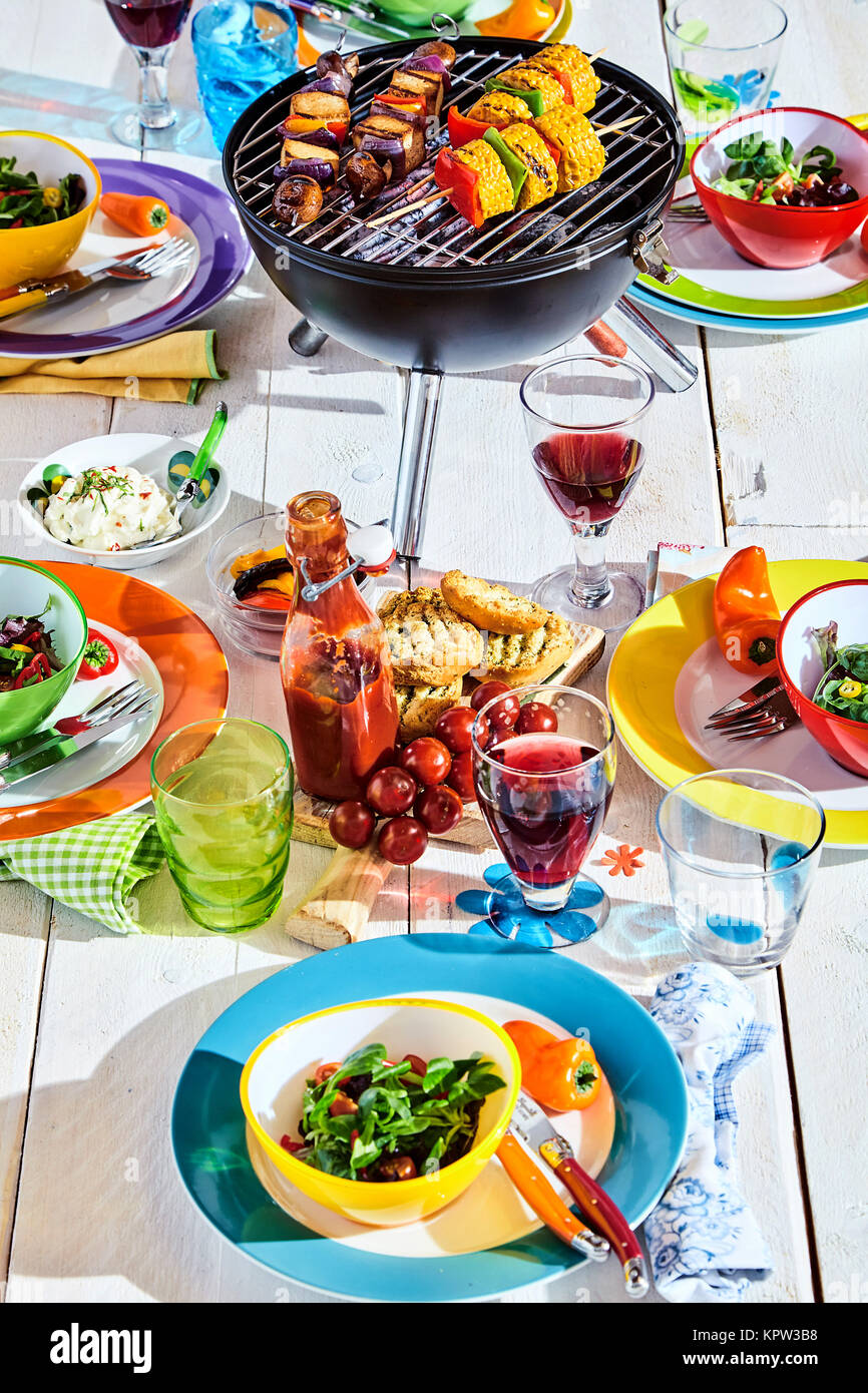 Well Laid summer table with colorful dish and plates and brazier on ...