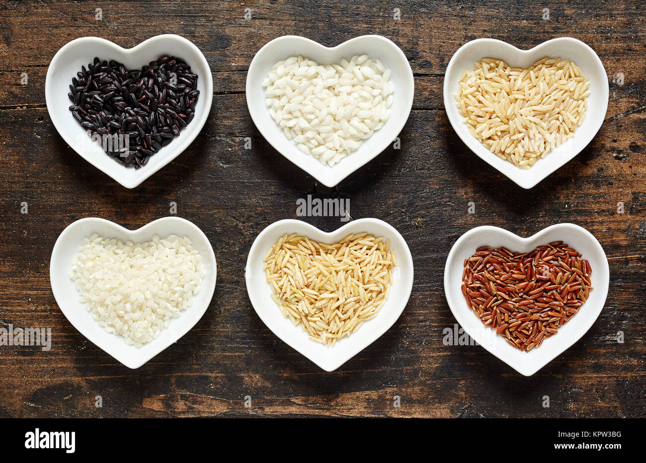 Selection of different rice grains in heart shaped dishes with par ...