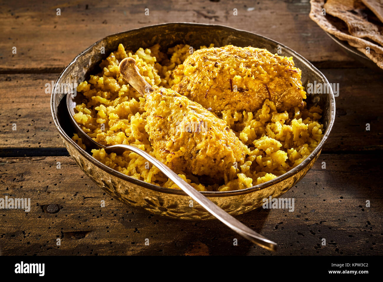 Steel pot and spoon with delicious and spicy chicken biryani drumstick ...