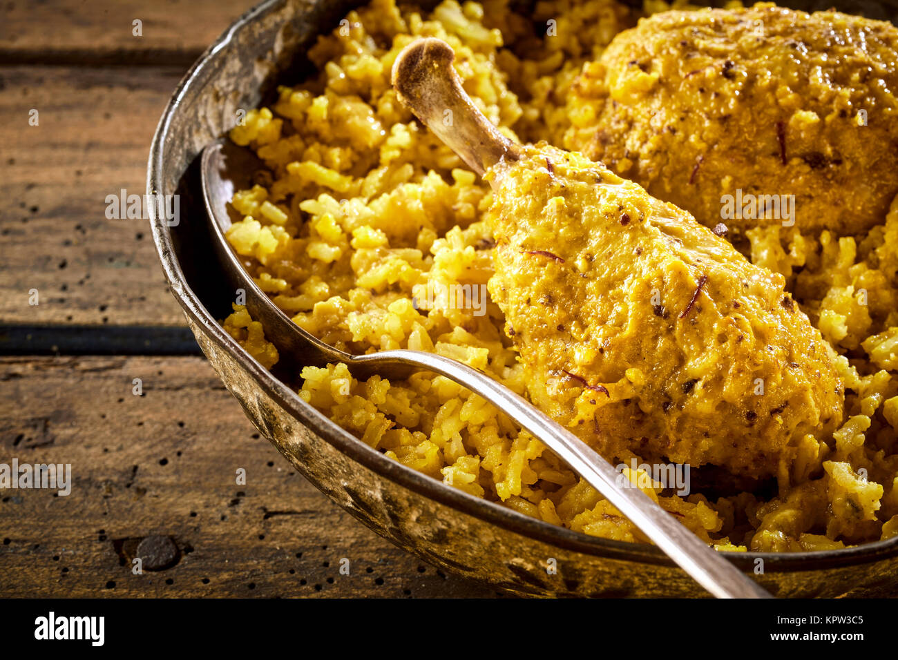 Detail view on steel pot and spoon with delicious and spicy chicken ...