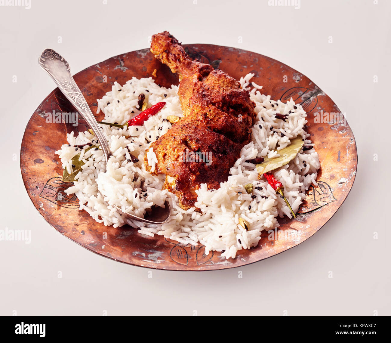 Rustic plate with indian chicken tandoori style herbed rice and spicy ...
