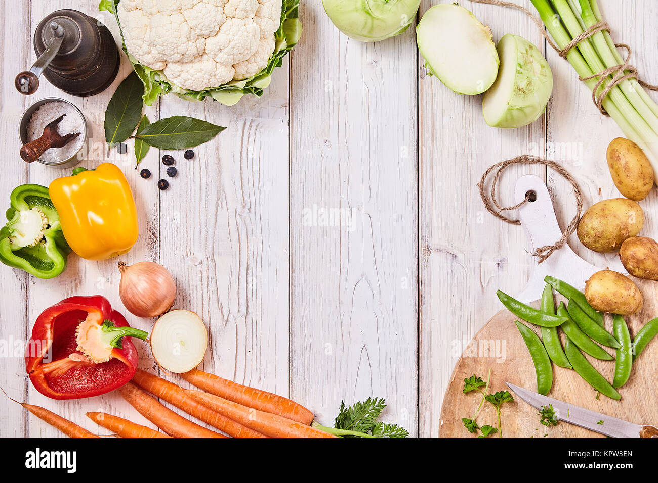 Delicious fresh vegetables forming a frame on white wood with central ...