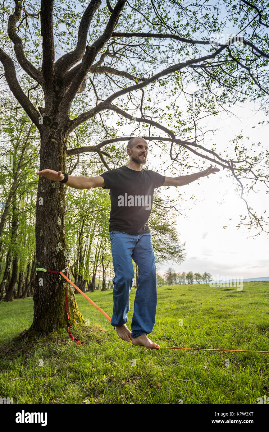 Young man slacklining Stock Photo - Alamy