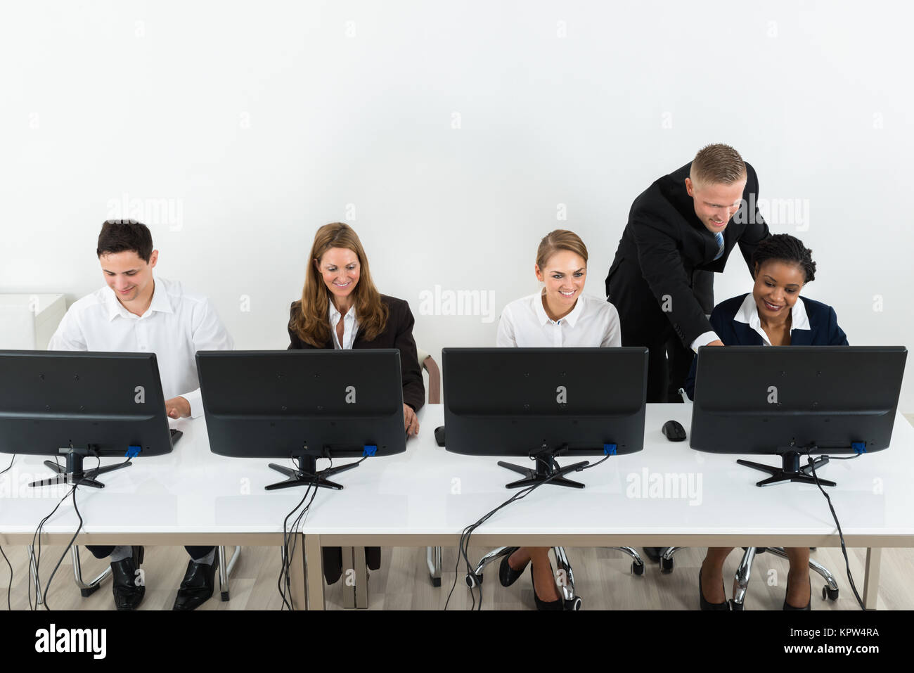 Businessman Helping His Colleagues In The Office Stock Photo - Alamy