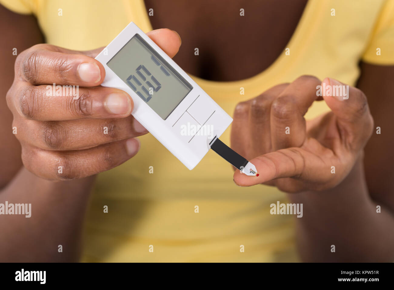 Woman Using Glucometer To Check Blood Sugar Level Stock Photo - Alamy