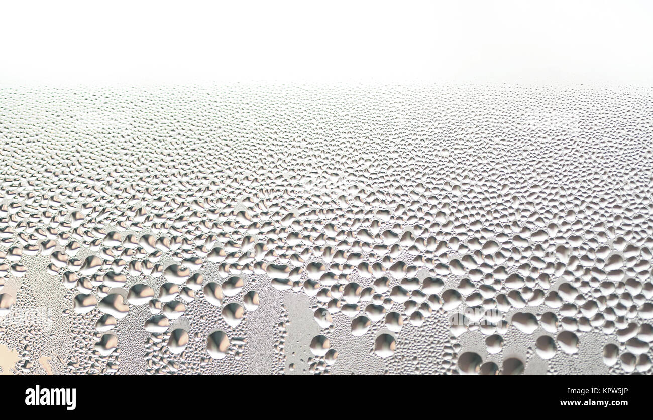 Condensation formed on glass surface of a window with silver water ...