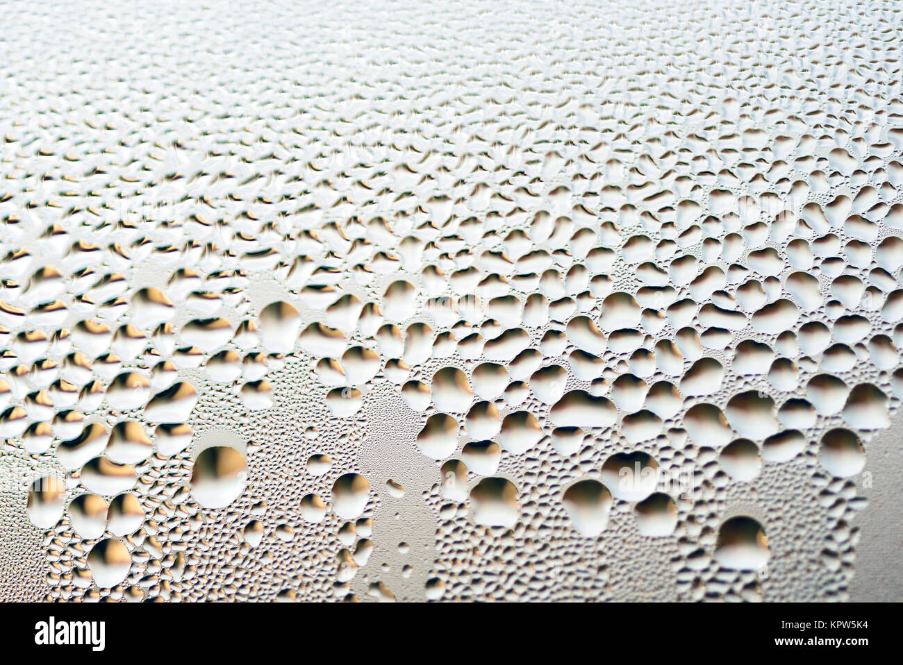 Condensation formed on glass surface of a window with silver water ...