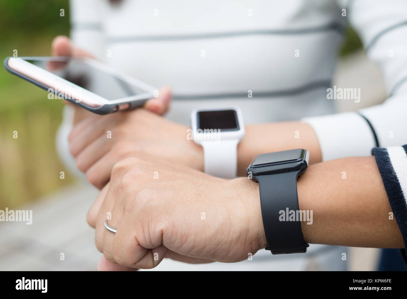 Two people using smartwatch together and connecting to cellphone Stock Photo - Alamy