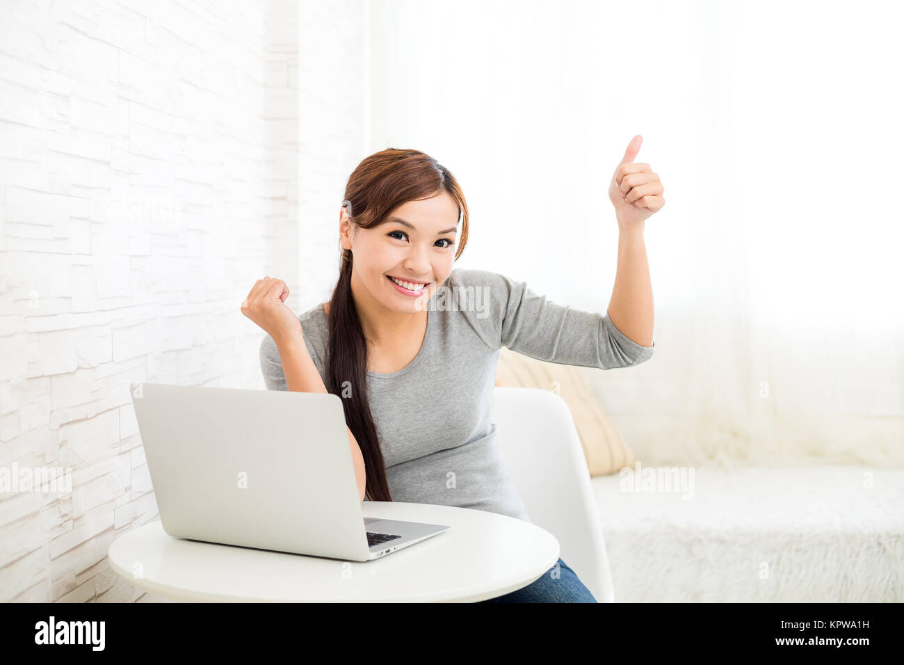 Excited woman use of laptop computer with thumb up gesture Stock Photo ...
